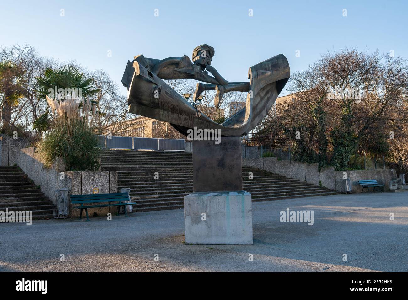 Monument depicting a person rowing on a river in a tranquil urban park ...