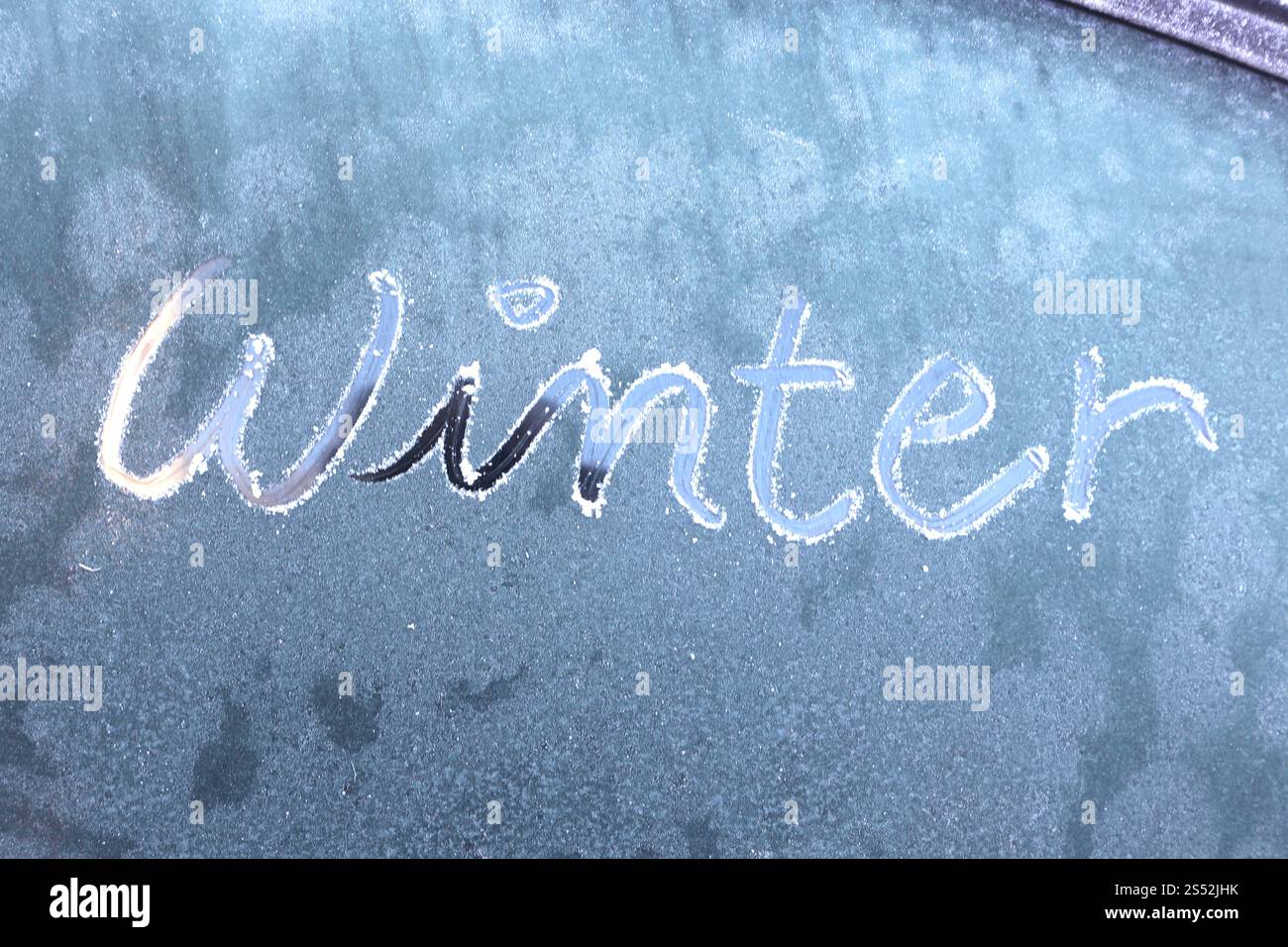 Eiskristalle auf der Scheibe eines Autos Das Wort Winter wurde in den ...