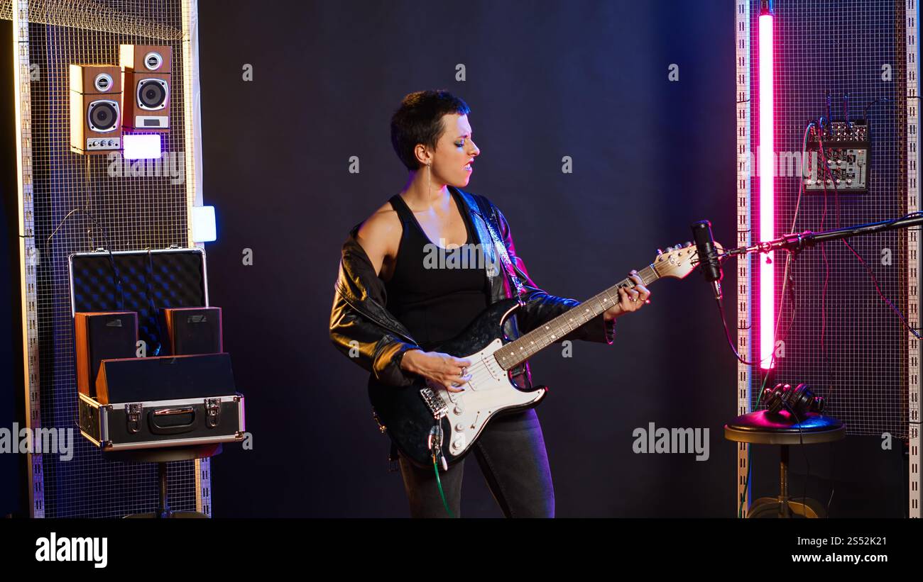 Woman performer showing thumbs up symbol and playing guitar, edgy ...