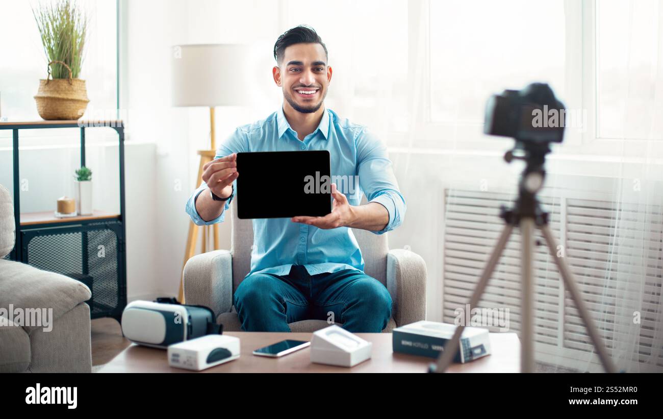 Arab guy influencer shooting video review of modern tablet computer on ...