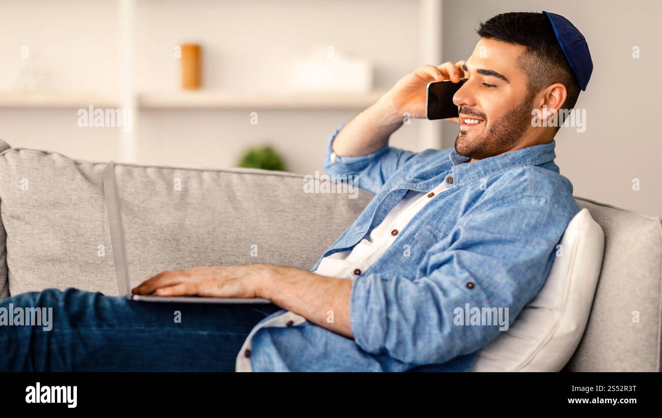 Portrait of positive israeli man talking on phone using pc Stock Photo ...