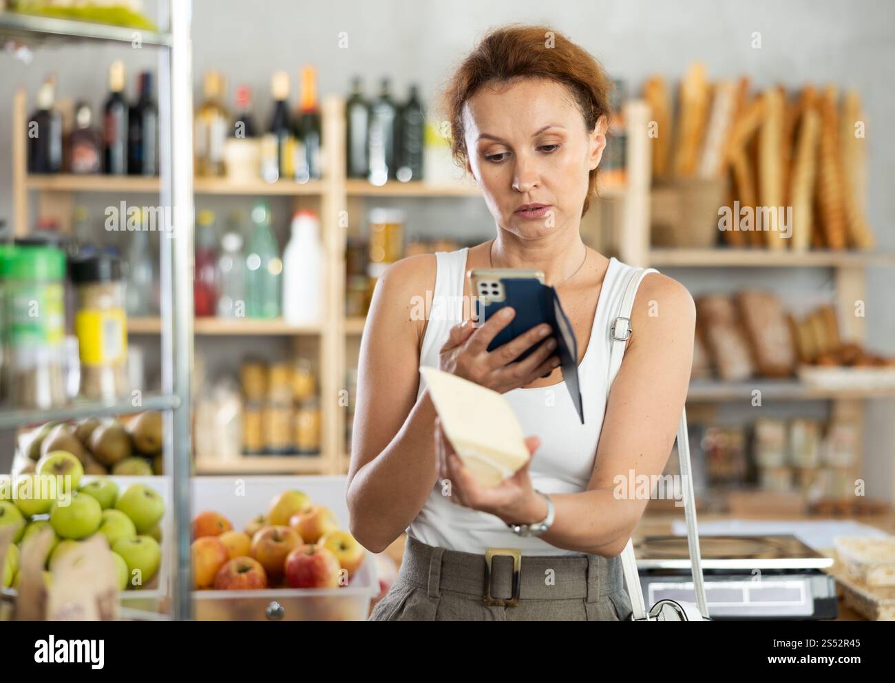 Adult woman scanning qr code of cheese Stock Photo - Alamy