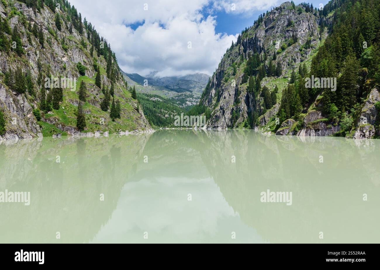 Summer Alps mountain landscape with turbid water reservoir lake and ...