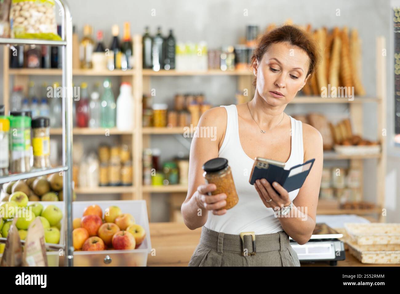 Female shopper scans QR code on lentils label using smartphone ...