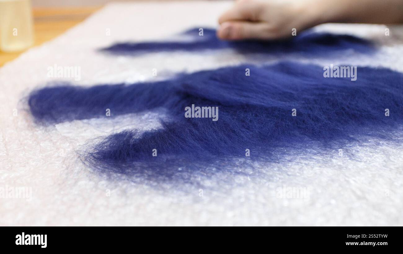 workshop of hand making a fleece gloves from blue Merino sheep wool ...