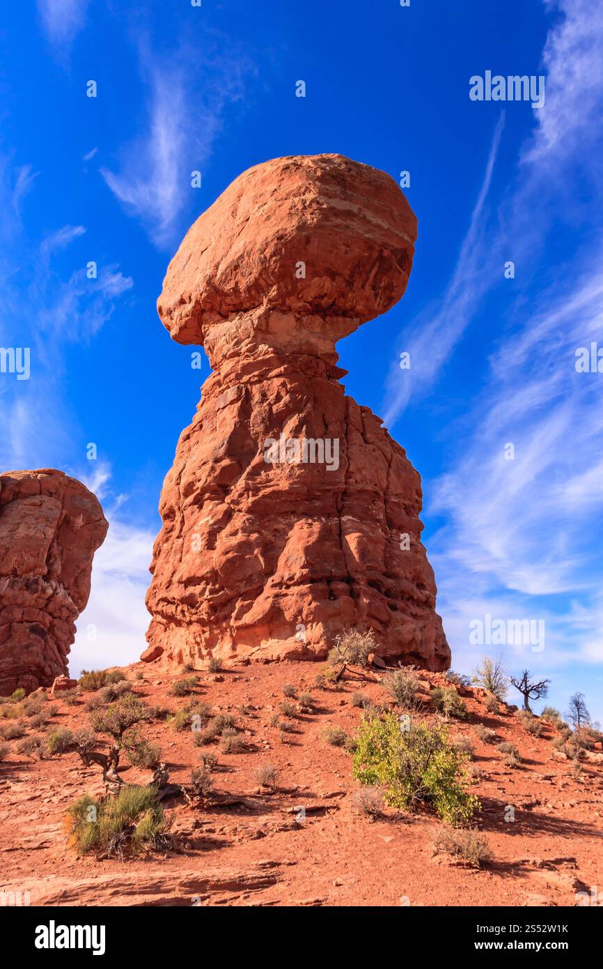 A large rock formation with a pointy top. The sky is blue and there are ...