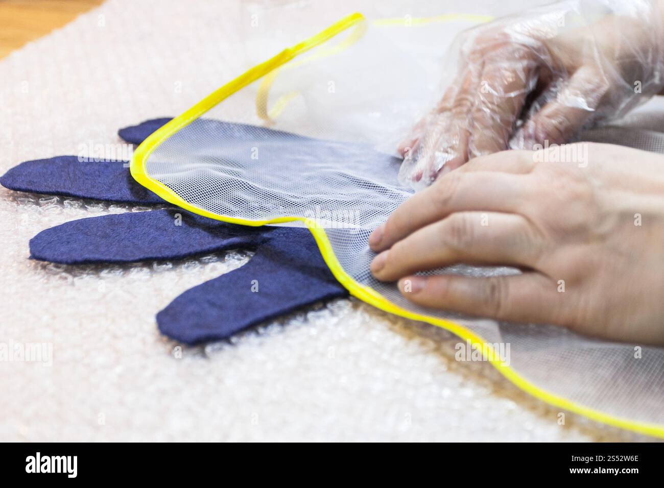 workshop of hand making a fleece gloves from blue Merino sheep wool ...