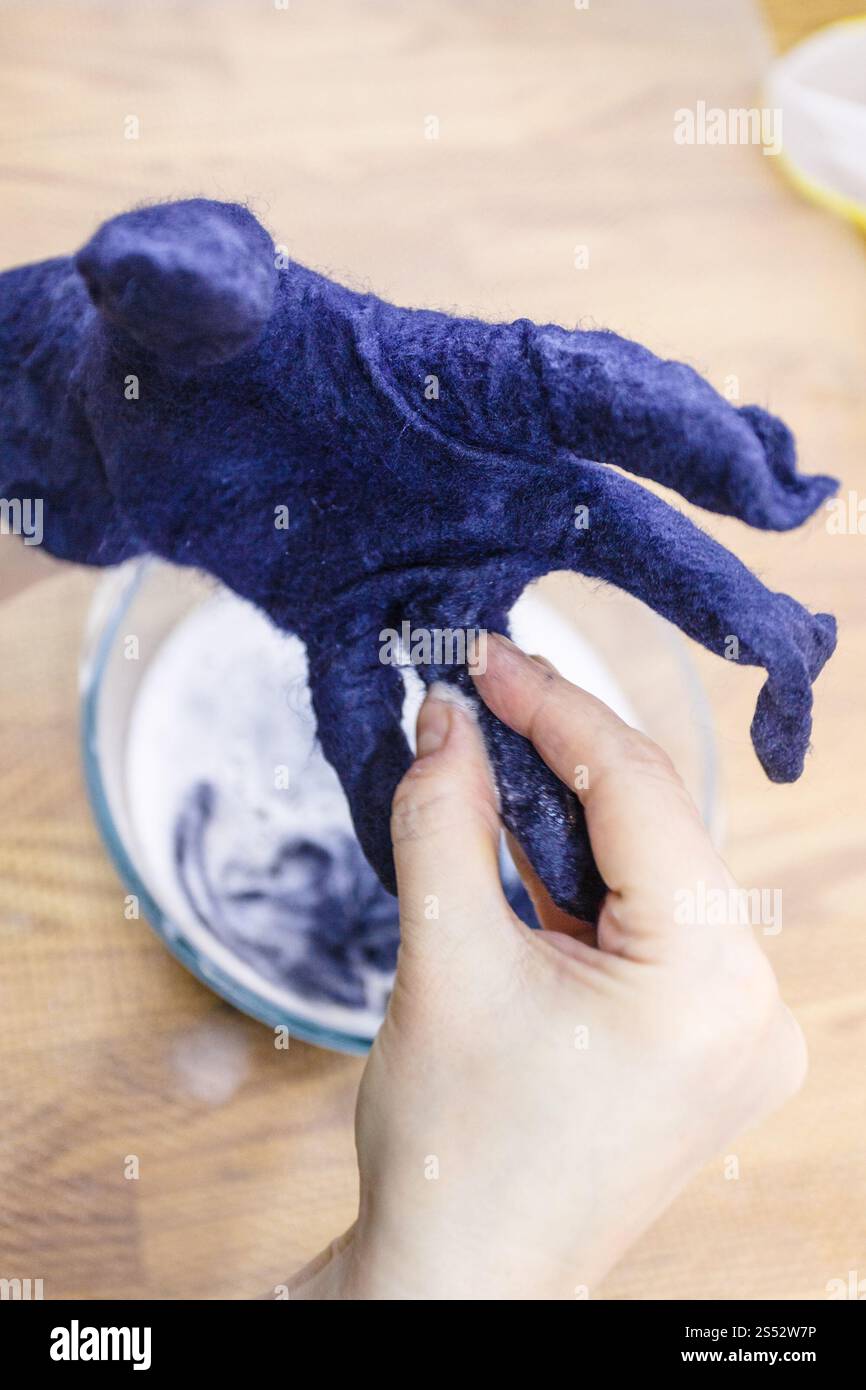 workshop of hand making a fleece gloves from blue Merino sheep wool ...