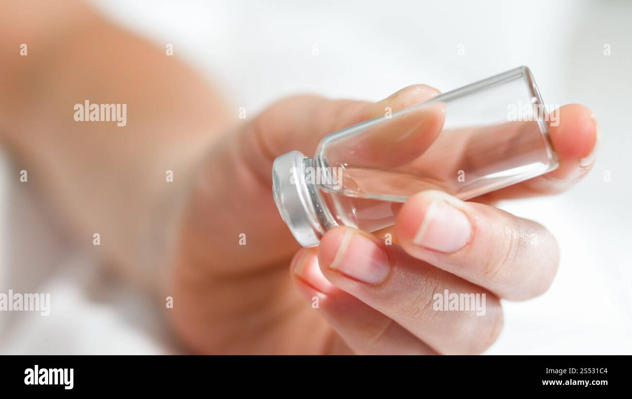 Closeup photo of nurse holding glass ampule with medication. Closeup ...