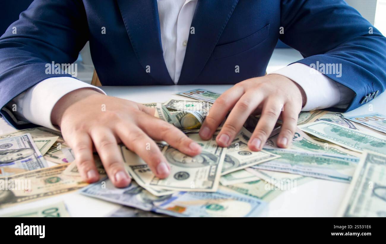 Conceptual image of greed and avarice. Businessman grabbing money lying ...