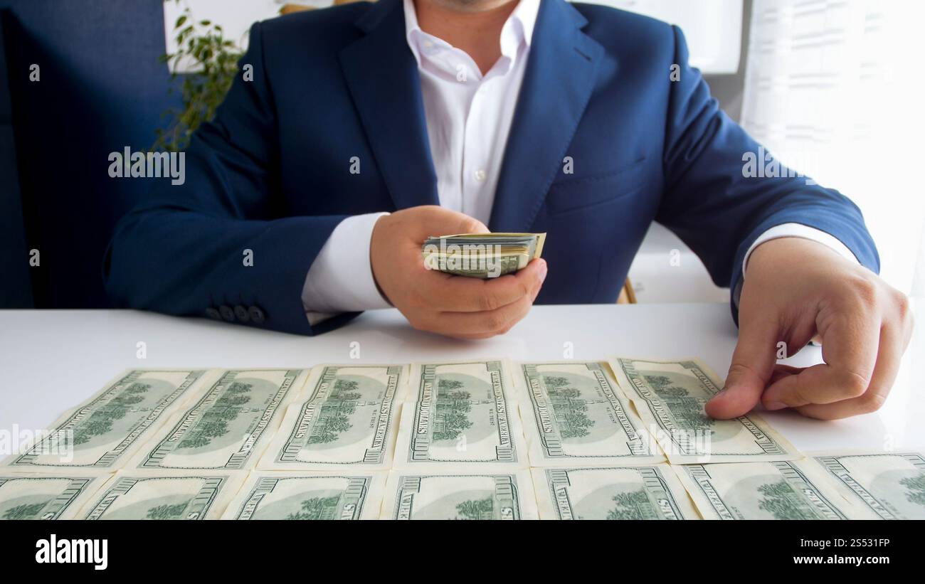 Closeup image of successful businessman laying money in front of him on ...