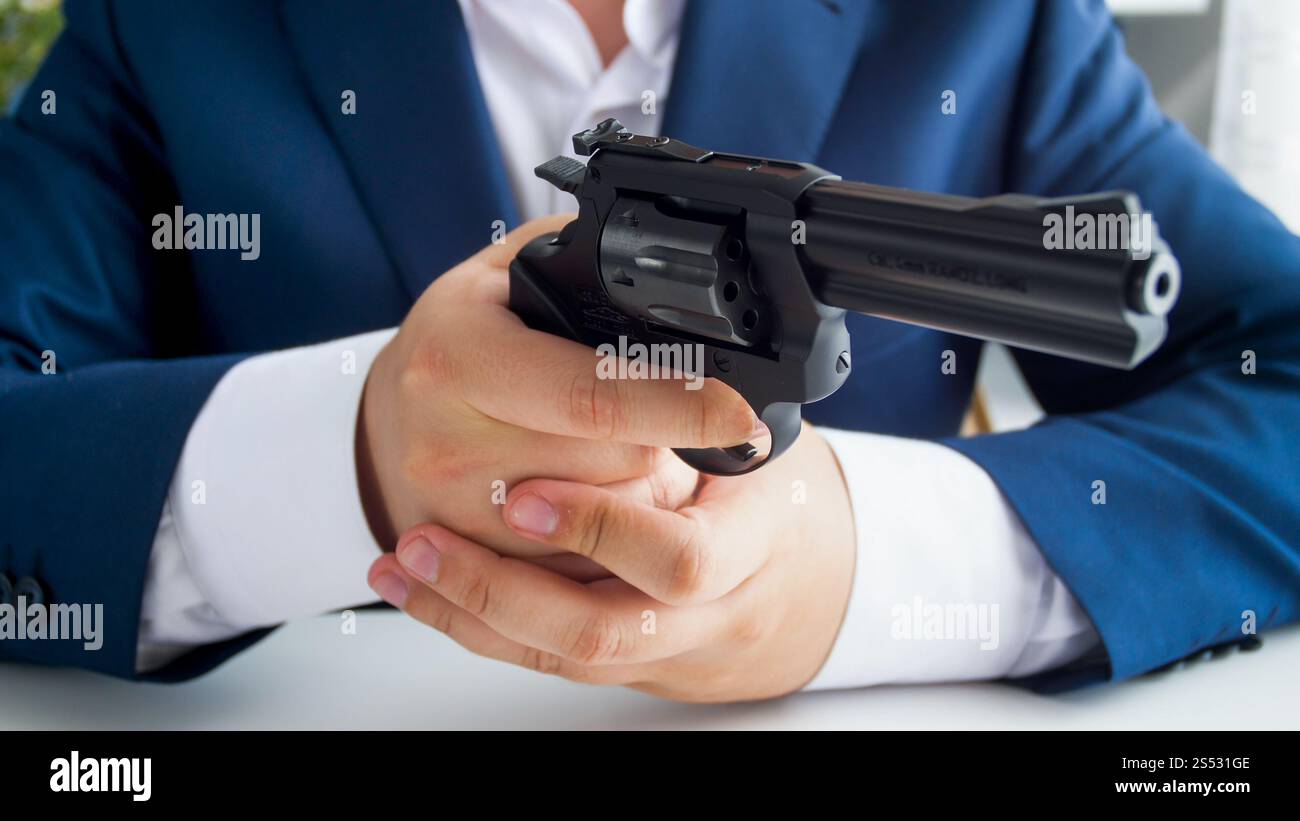 Closeup photo of man in suit holding and aiming with gun. Closeup image ...