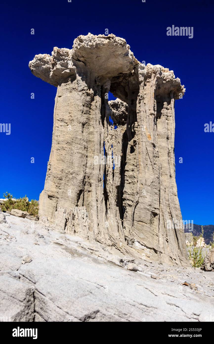 A large rock formation with a hole in the middle. The sky is blue and ...