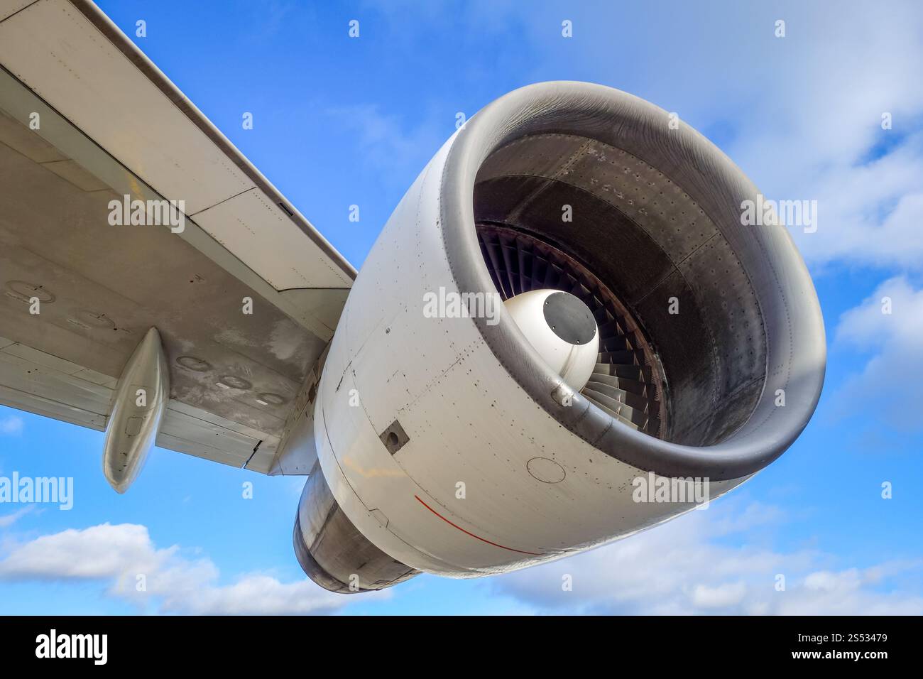 Airplane engine and wing on airport tarmac. Blue sky. Airplane engine ...