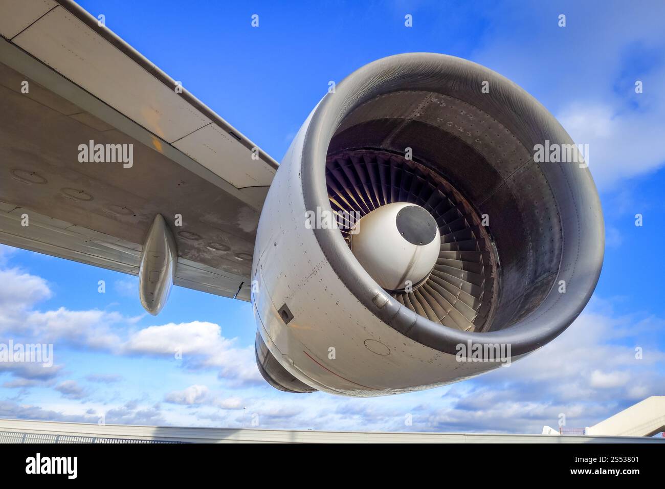 Airplane engine and wing on airport tarmac. Blue sky. Airplane engine ...