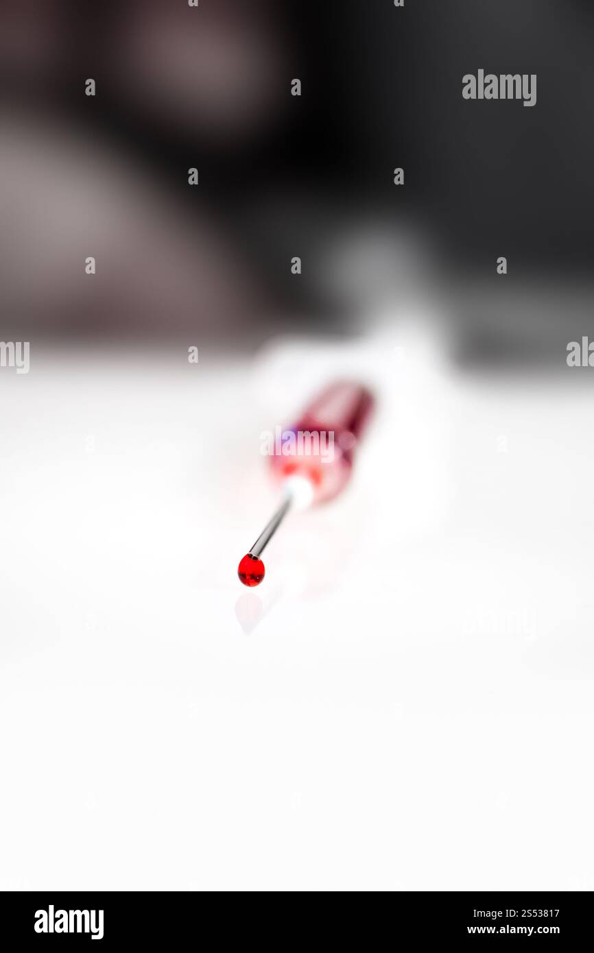 Syringe needle with blood drop macro view. Syringe needle with blood ...