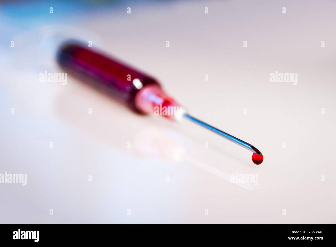 Syringe needle with blood drop macro view. Syringe needle with blood ...