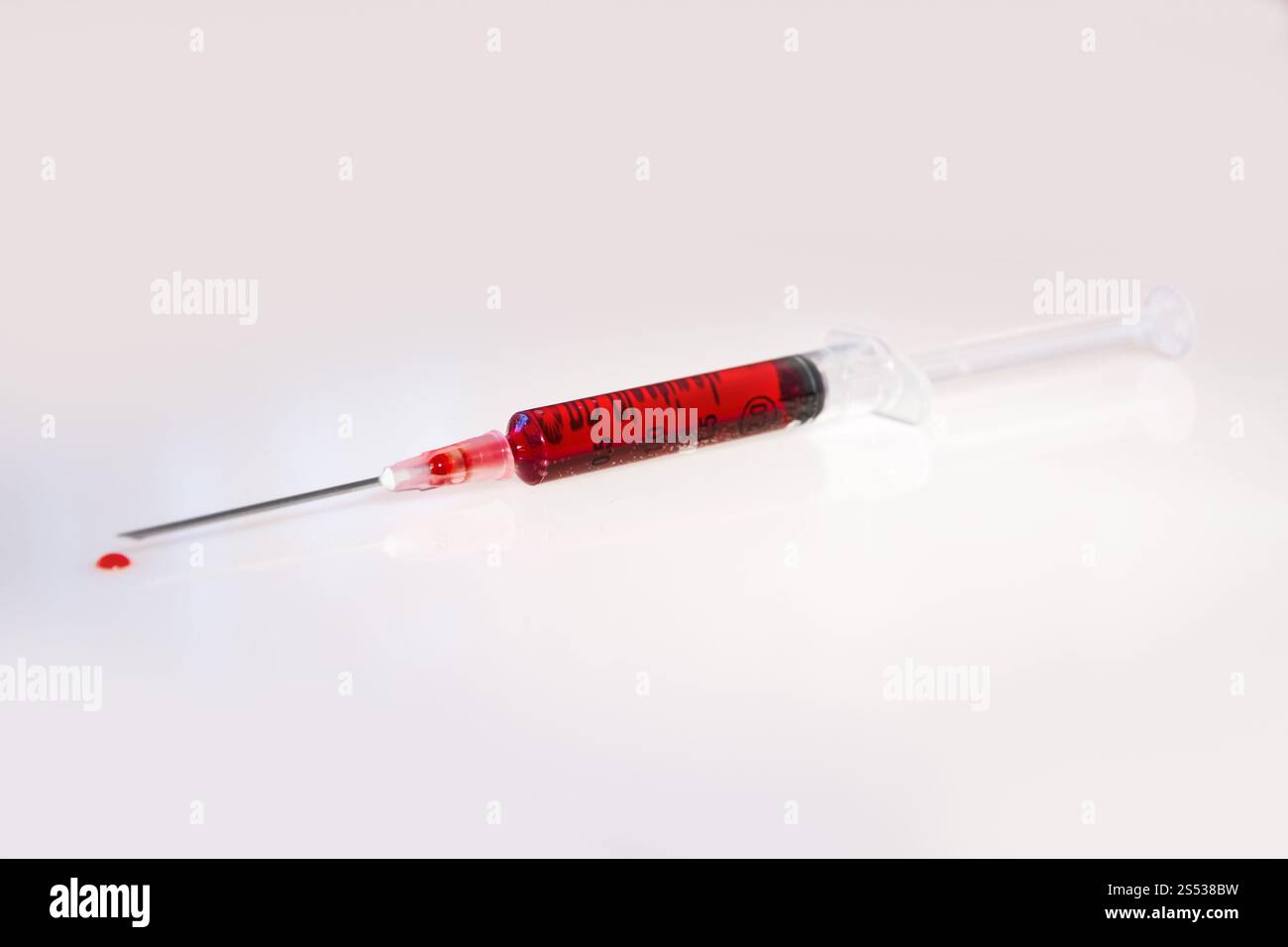 Syringe with blood closeup on white background. Syringe with blood on ...