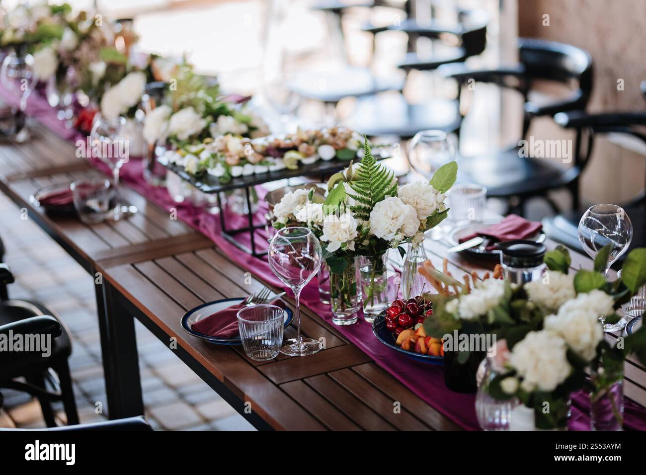 Luxurious dining table setup with flowers, appetizers, and wine glasses for an elegant ...