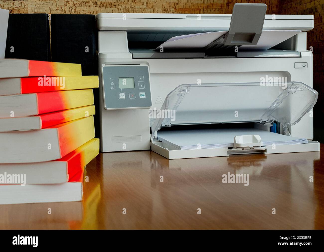 printer and a stack of books on his desk. Office concept Stock Photo ...