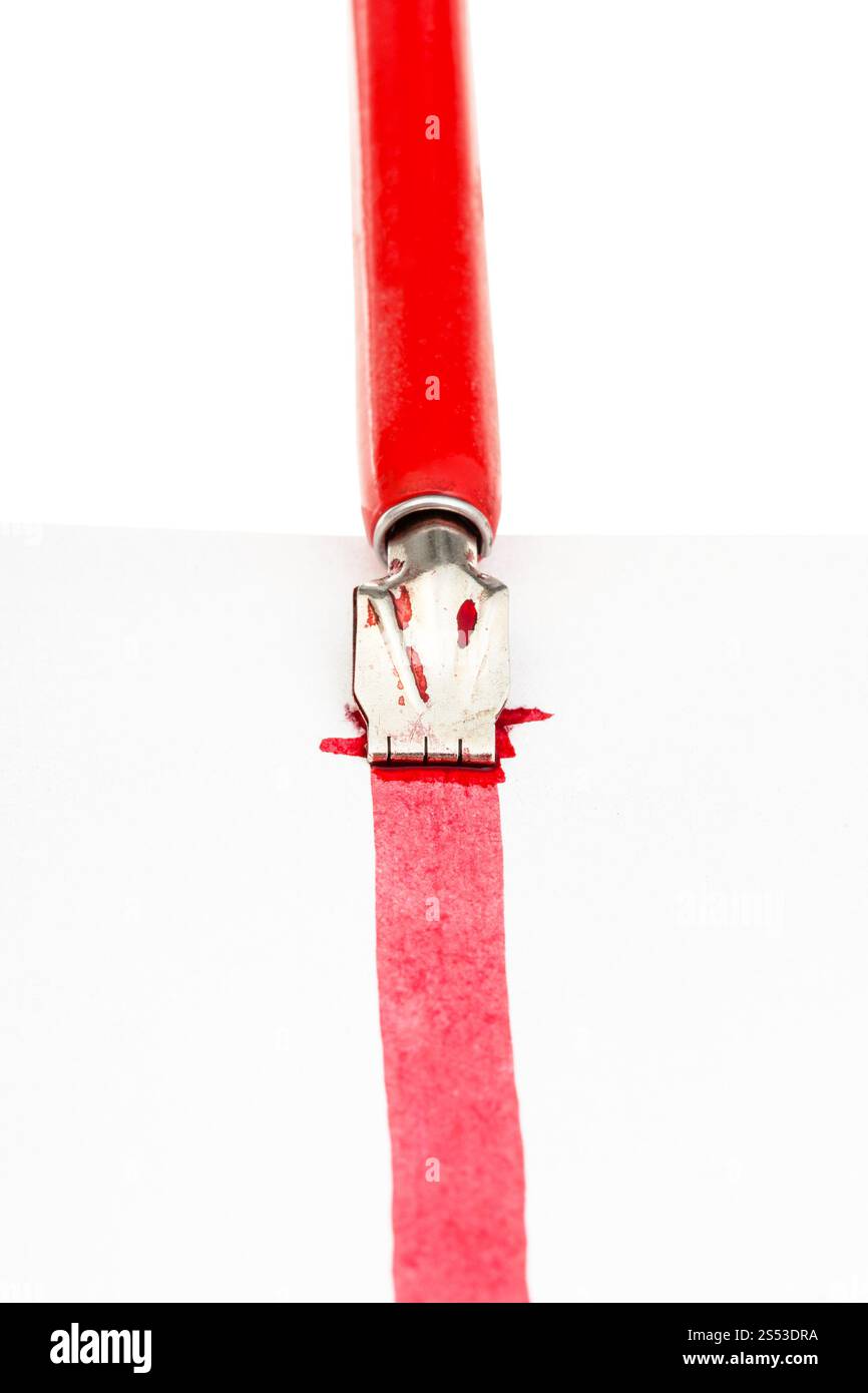red dip pen draws a red line on sheet of paper by wide nib close up ...