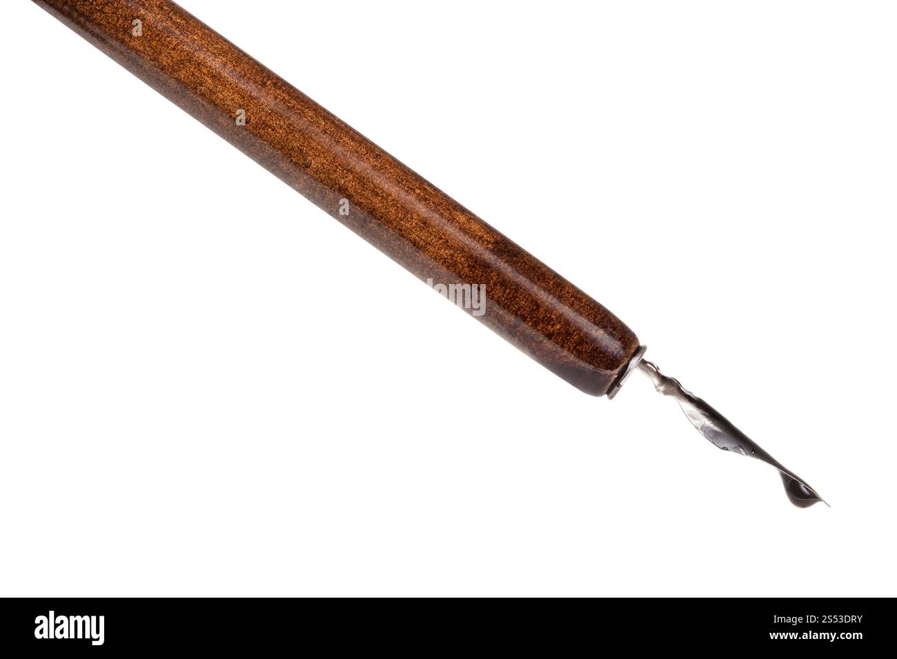 side view of black ink drop on tip of nib of brown dip pen close up ...