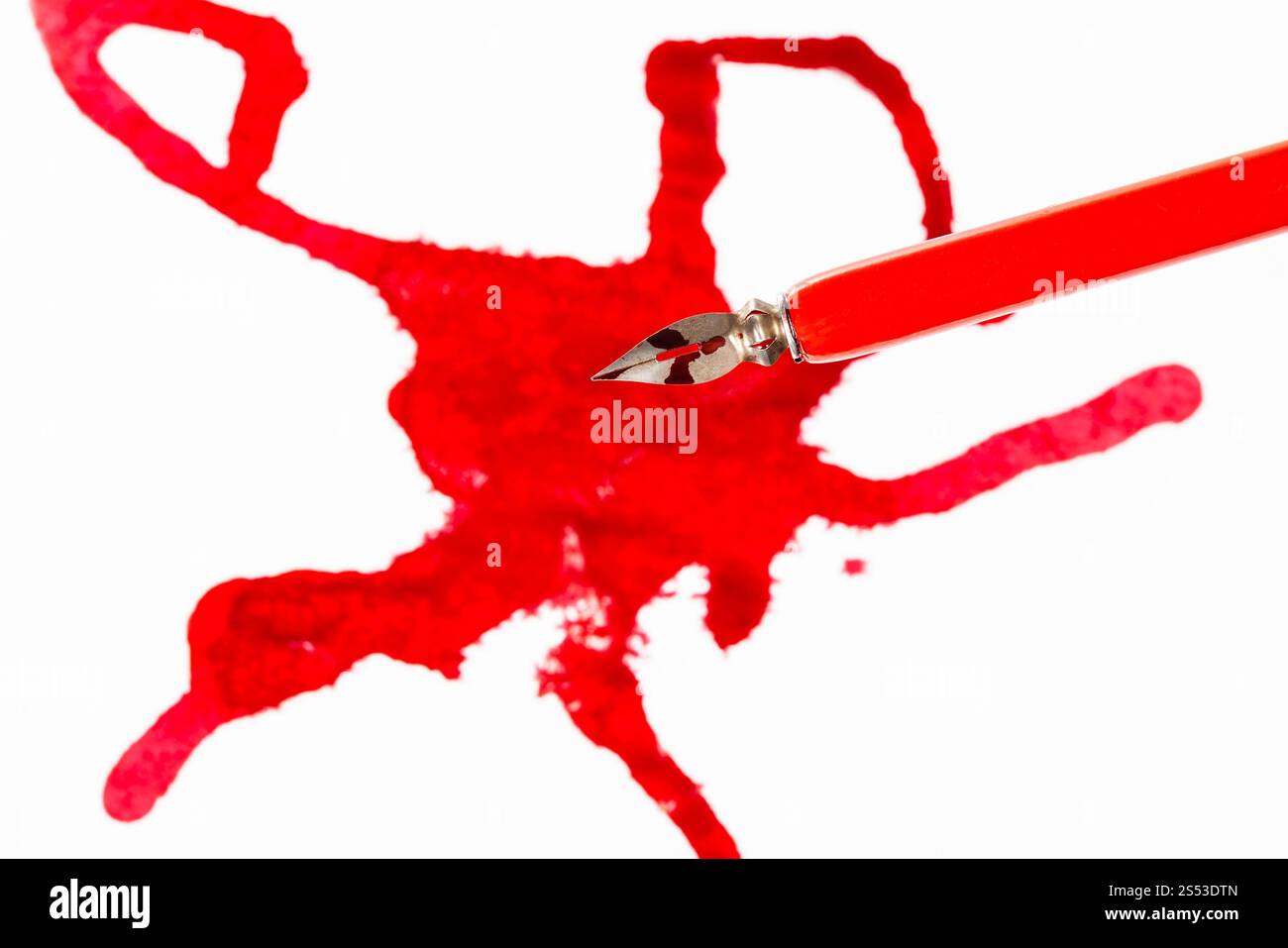 top view of red dip pen over red ink stain on white paper Stock Photo ...