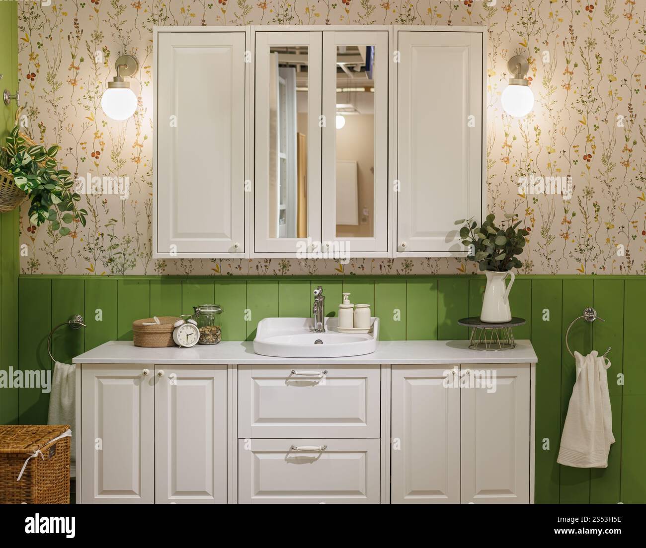 A stylish bathroom with white furniture, a matching mirror, and walls ...