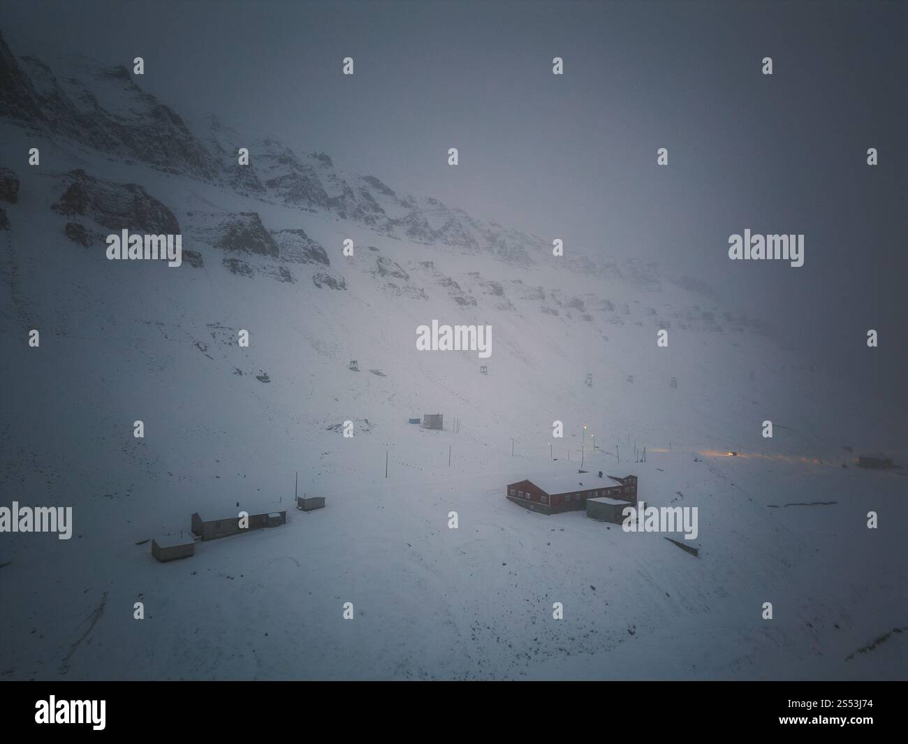Aerial view of buildings in the snow under mountain in Longyearbyen ...