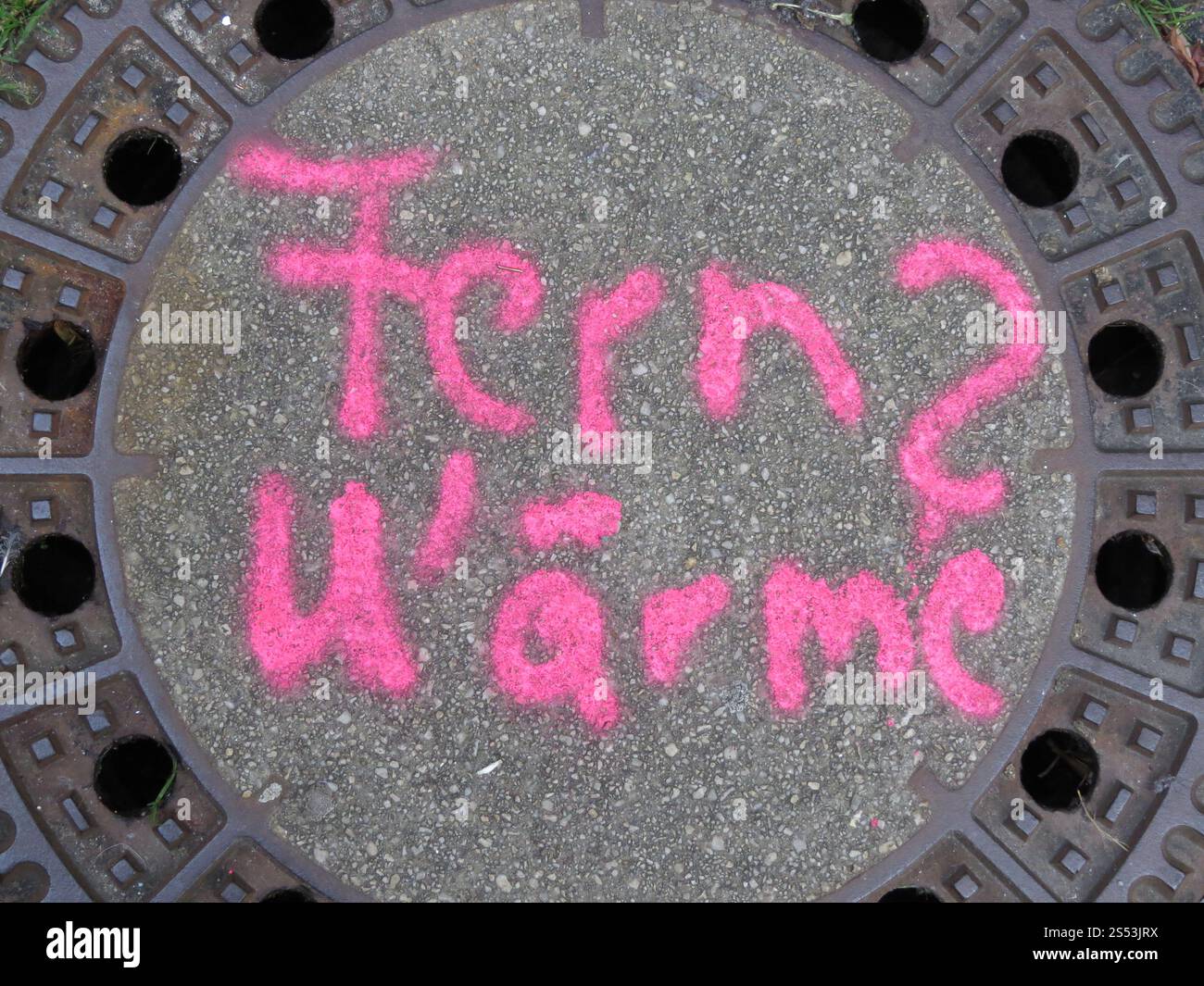 Graffiti In Neon Pink "District Heating?" Sprayed On A Manhole Cover ...