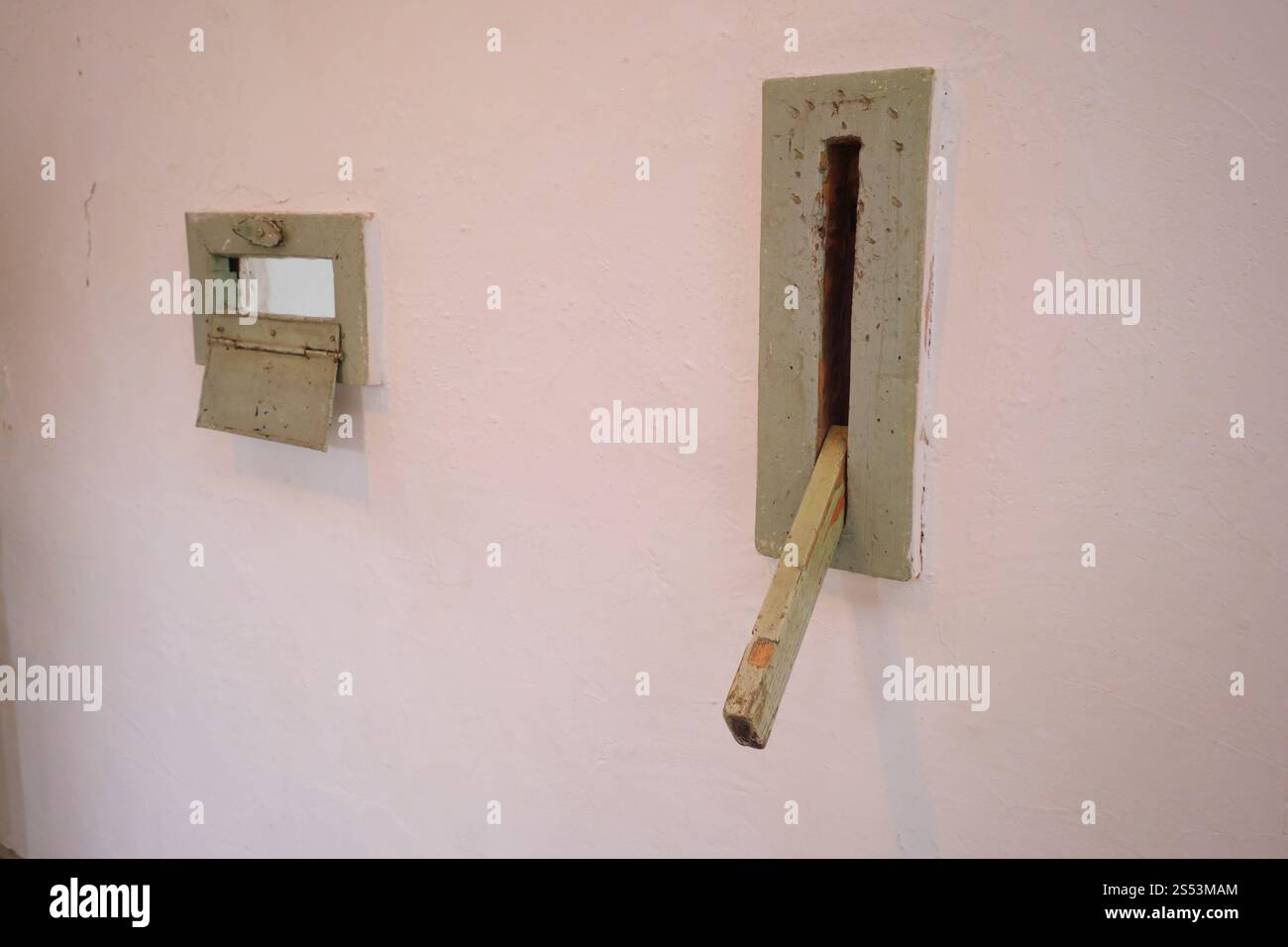 A wall lever, flap passthrough, security measure in a cell wall. At the ...