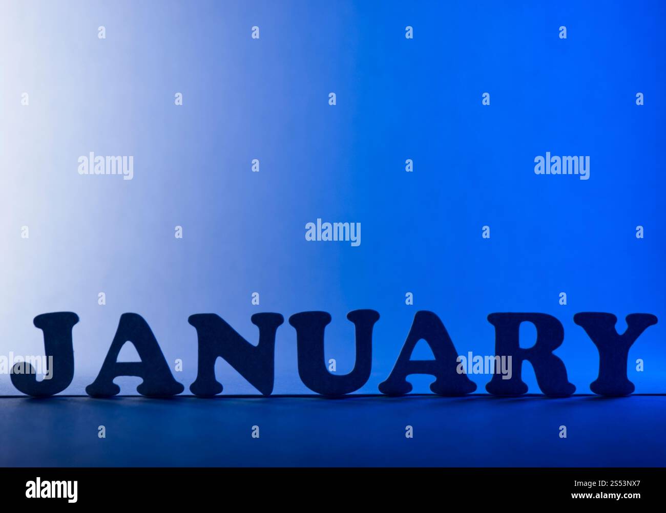 Silhouette of letters against blue spelling January Stock Photo - Alamy
