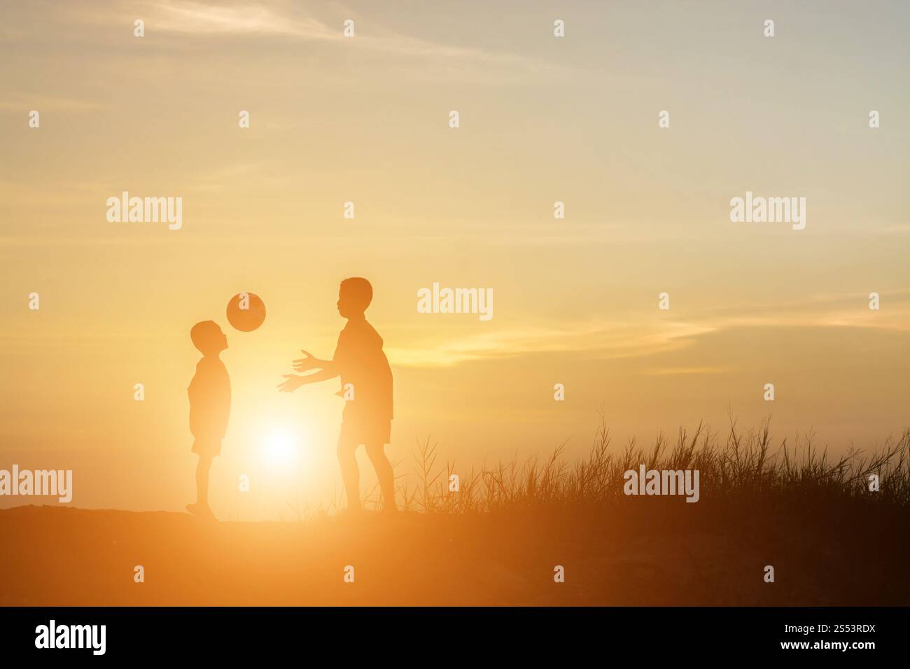 boys playing football at sunset. silhouette concept Stock Photo - Alamy