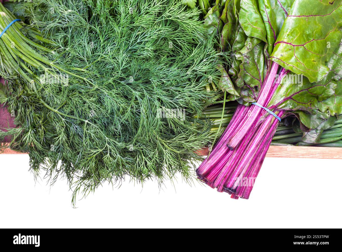 top view of bundles of beet tops and fresh dill close-up on wooden tray ...