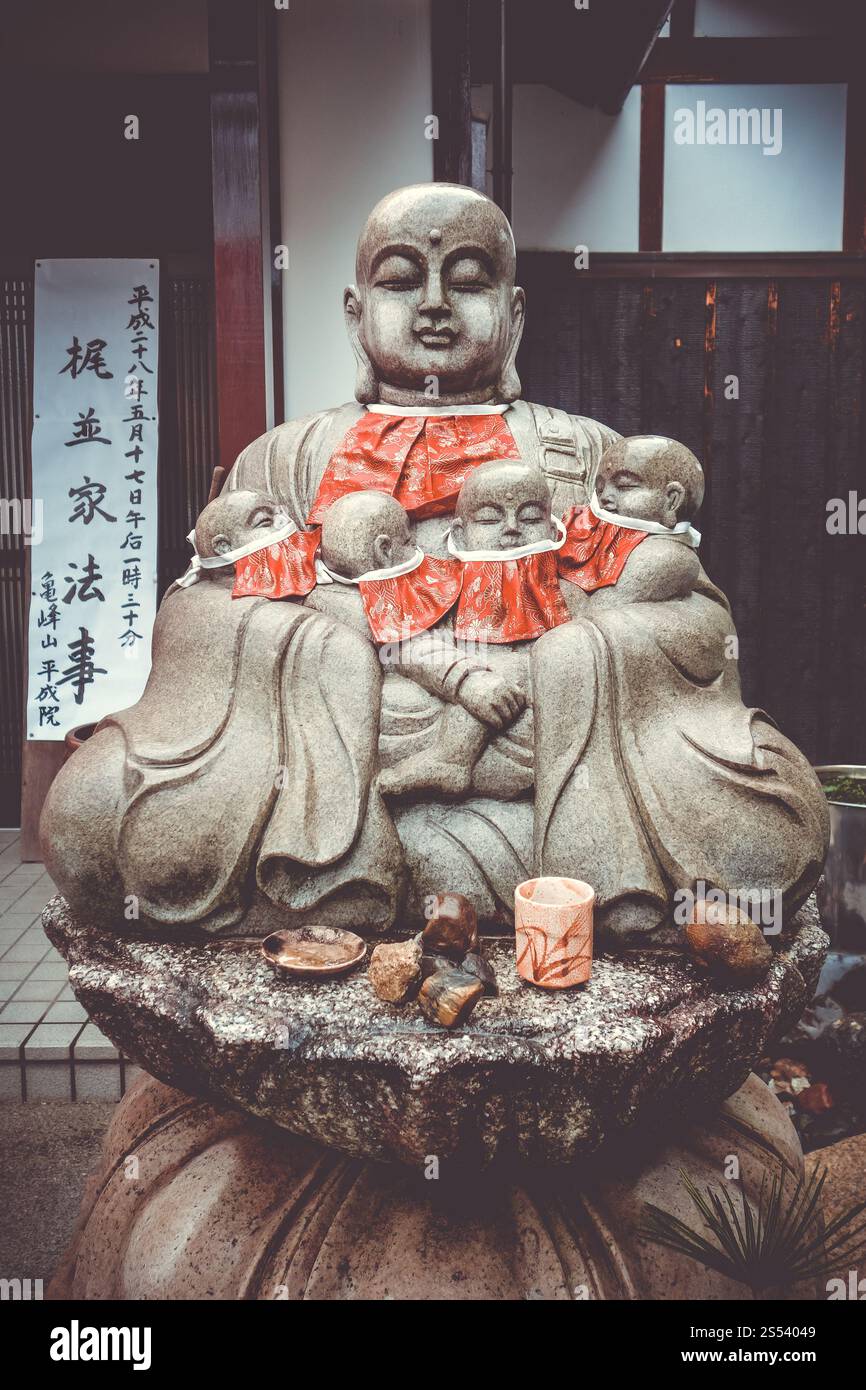 Jizo statue with red bibs in Arashiyama temple, Kyoto, Japan. Jizo ...