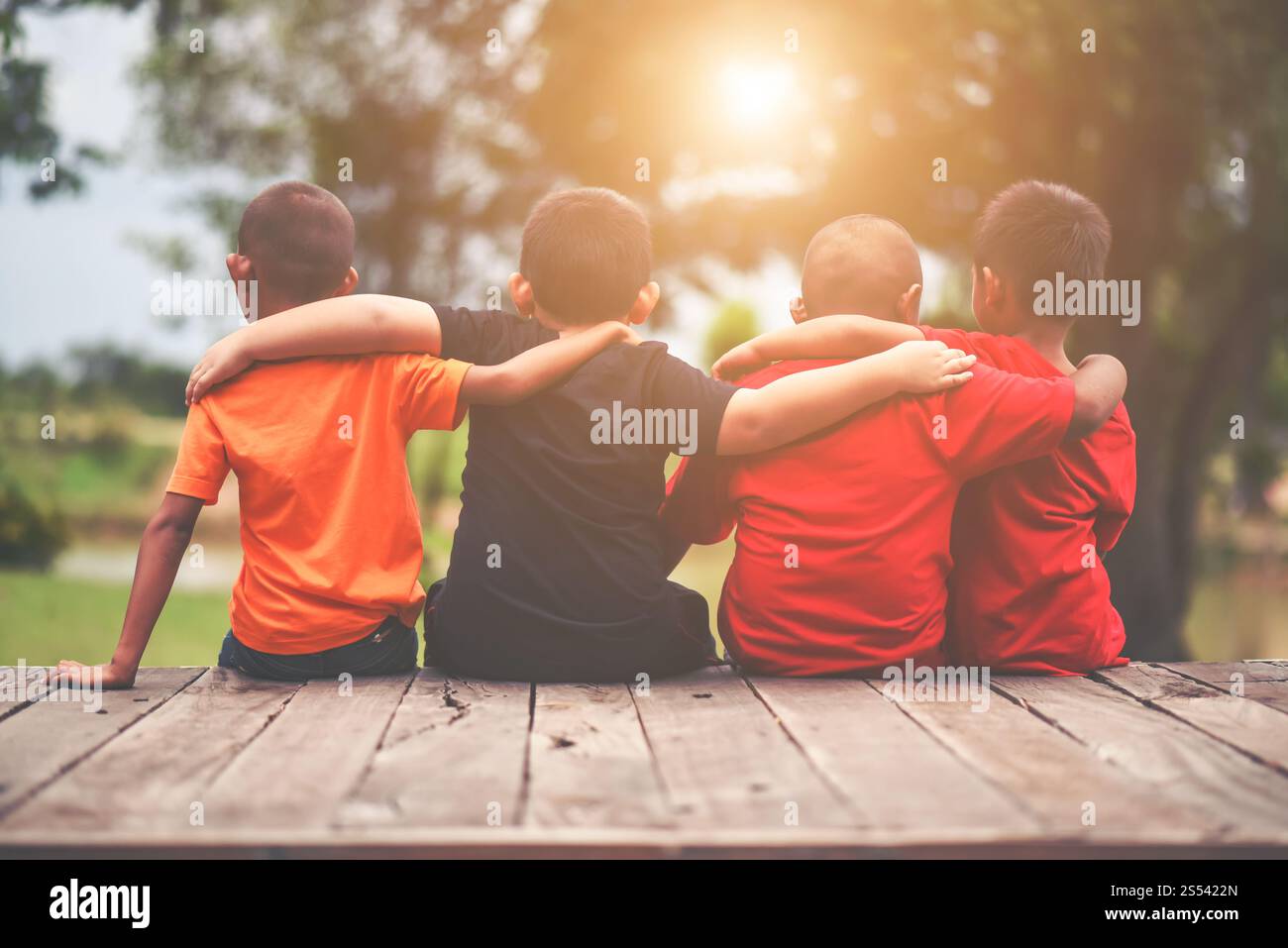 Group of kids friends arm around sitting together Stock Photo - Alamy