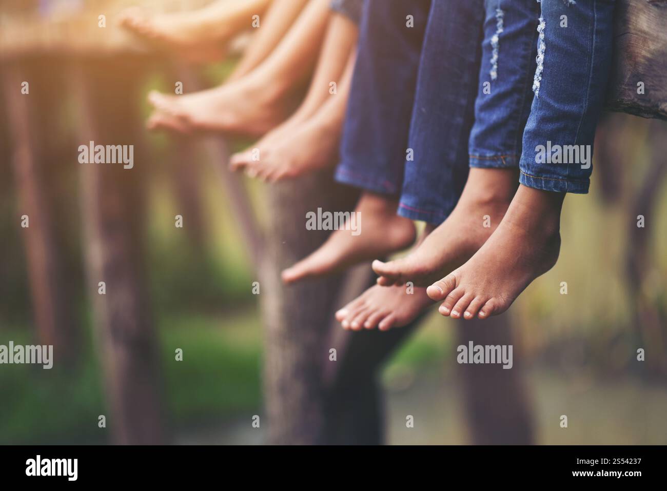 Feet of children sitting relaxed on the park Stock Photo - Alamy
