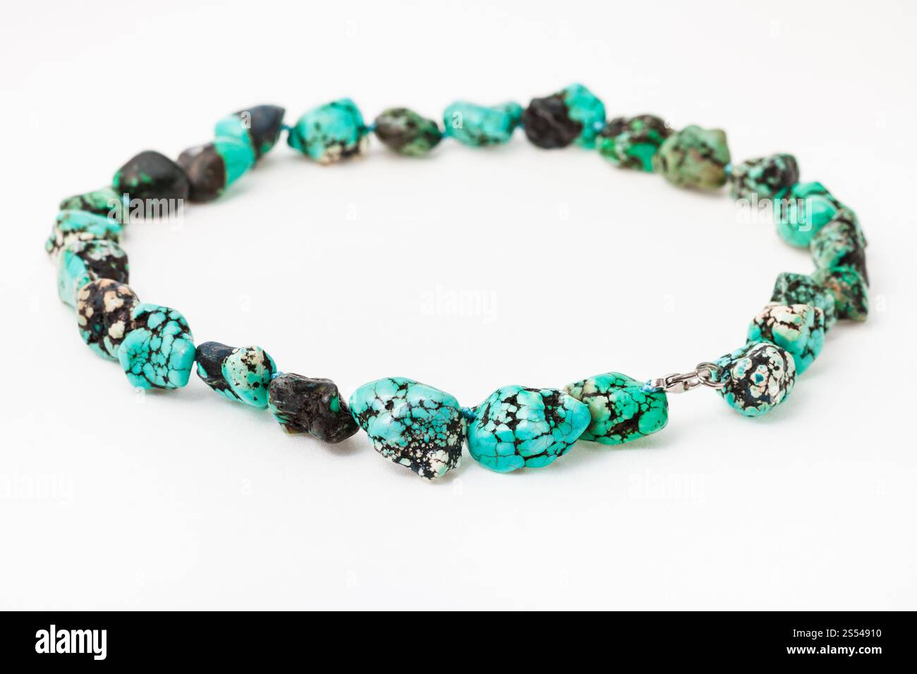 string of beads from natural tumbled dyed howlite gemstone on white ...