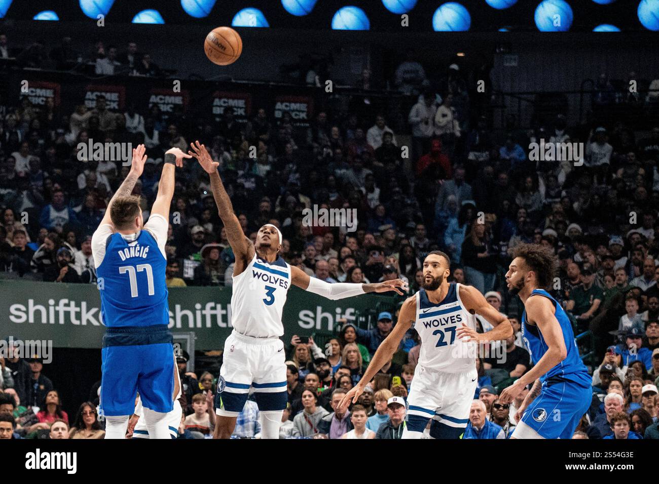Dallas Mavericks guard Luka Doncic (77) attempts a three-point shot over Minnesota Timberwolves ...