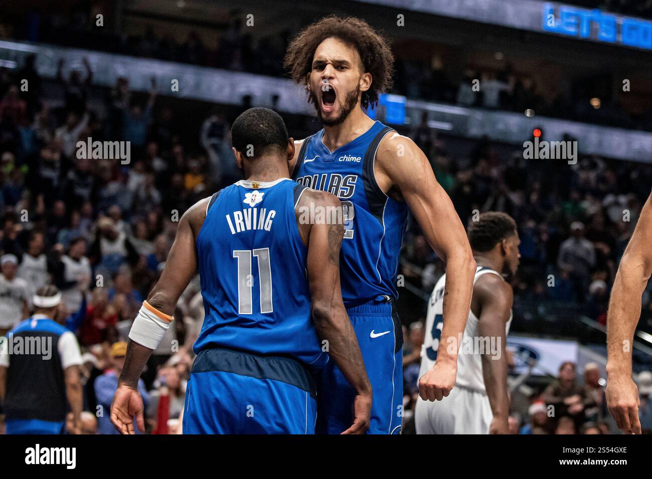 Dallas Mavericks guard Kyrie Irving (11) chest bumps center Dereck ...