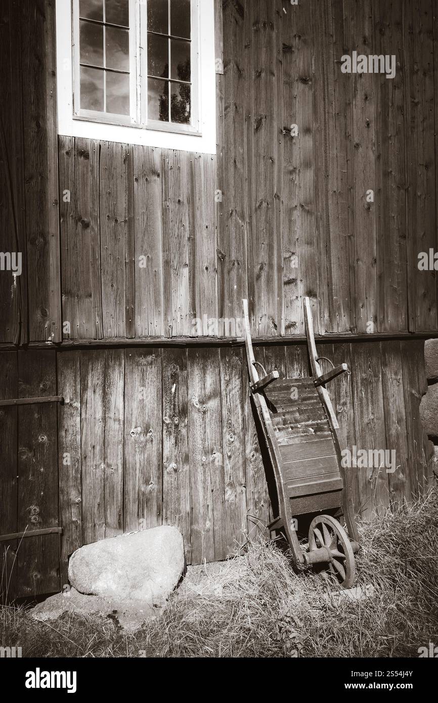 Old wooden wheelbarrow on a farm wall. Black and White photography ...