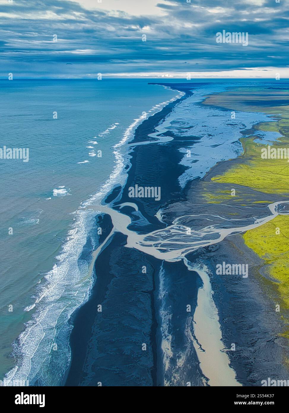 Aerial view of Iceland’s black sand beach and braided rivers meeting ...