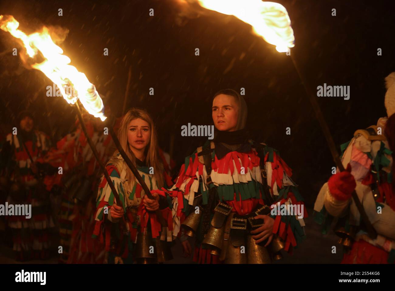 Bulgarian kukeri dancers hold their torches as they perform Surva ...