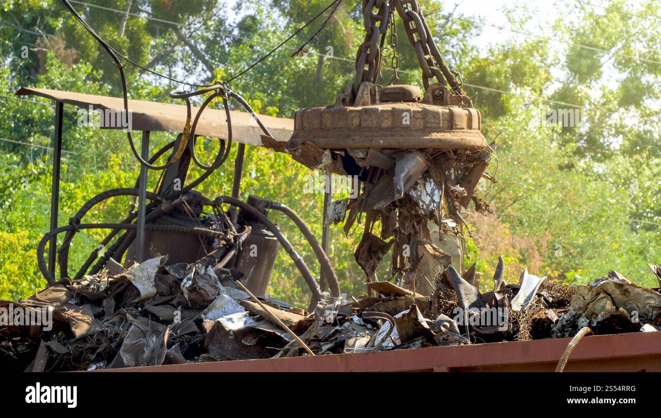 Image of big electric magnet sorting and lifting metal part and waste ...