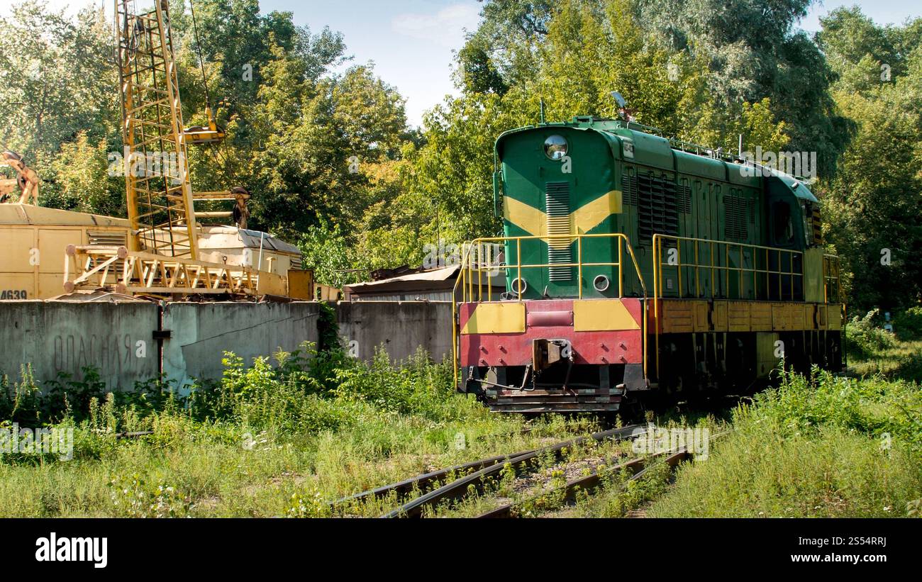 Old diesel train riding on railroad at old factory or construction site ...