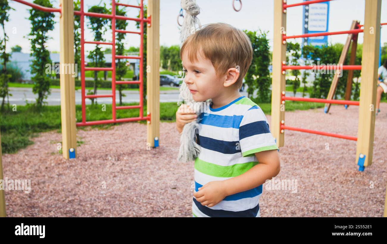Portrait of happy smiling toddler boy playing with big rope for ...