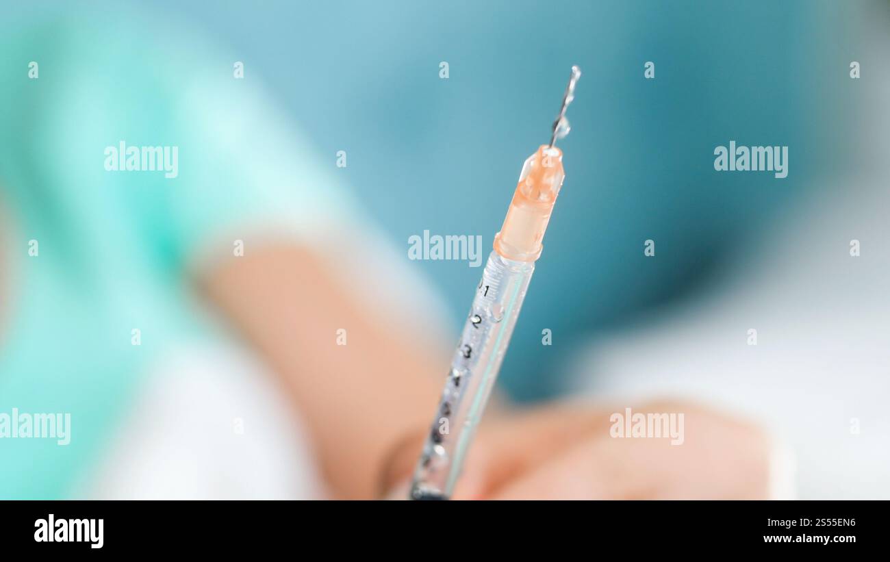Closeup image of droplets of medicines on the syringe needle edge ...