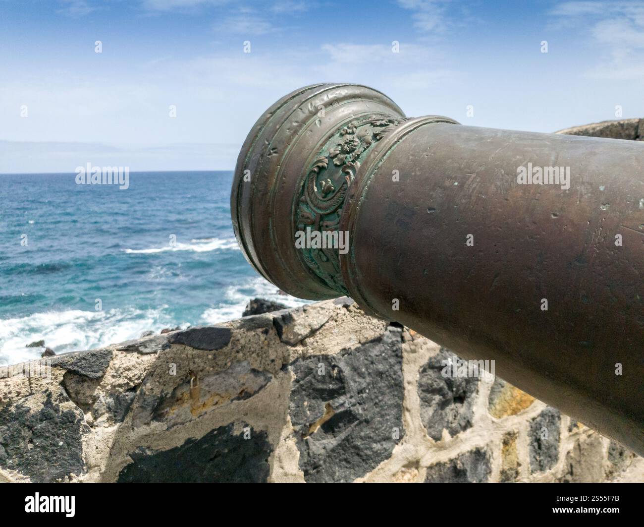 Closeup photo of decorated muzzle of bronze cannon at old stone ...