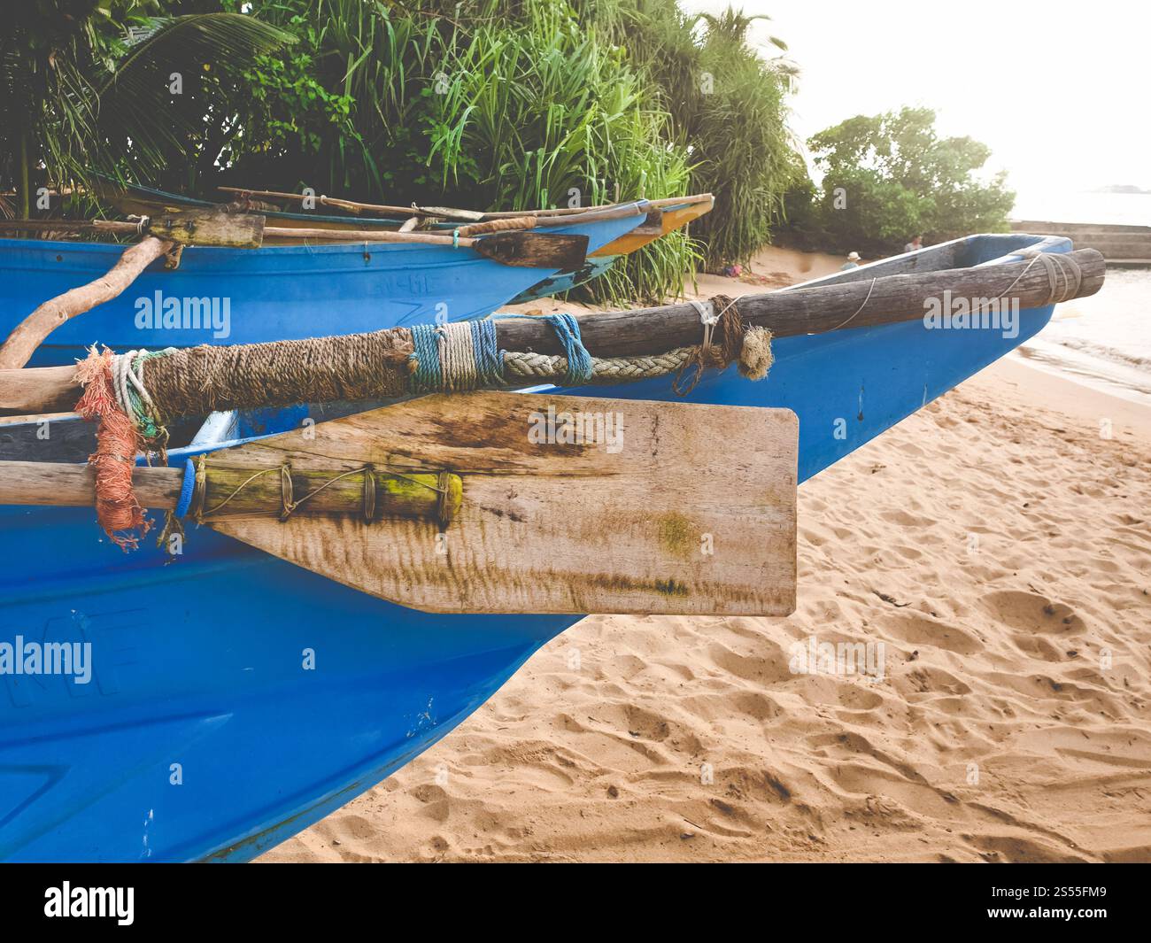 Toned photo of oars and paddles at old wooden boats for fishing on the ...