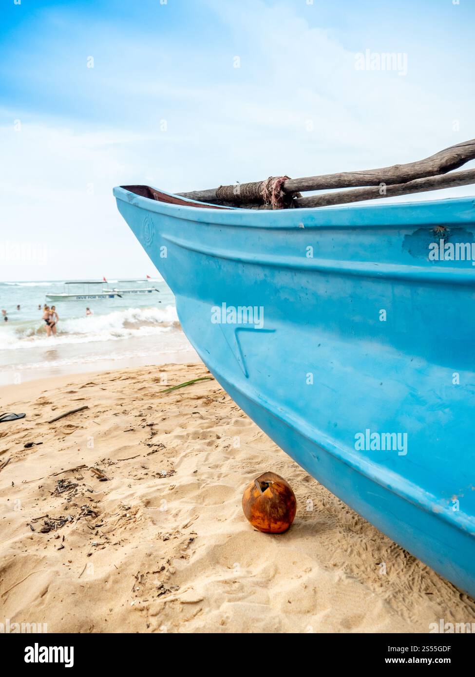 Closeup image of yellow coconut lying on the ocean baech next to old ...